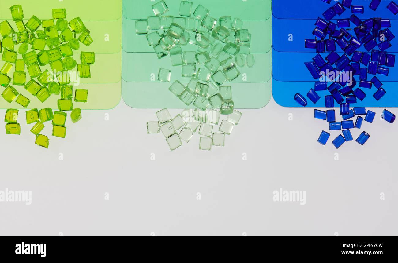 multicolored transparent plastic granulates with its color samples ...