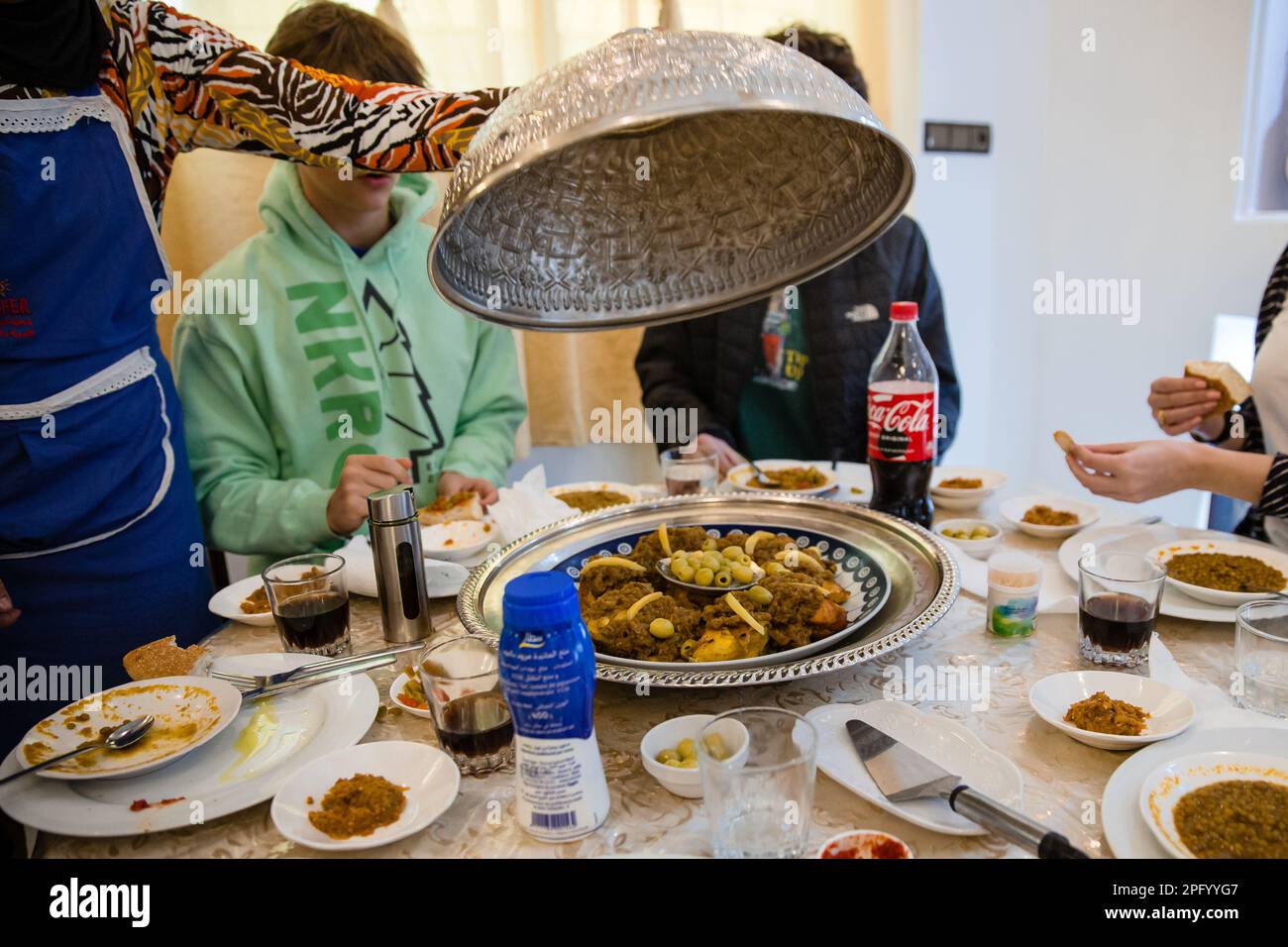 American tourists get ready to eat while a woman presents the meal in ...