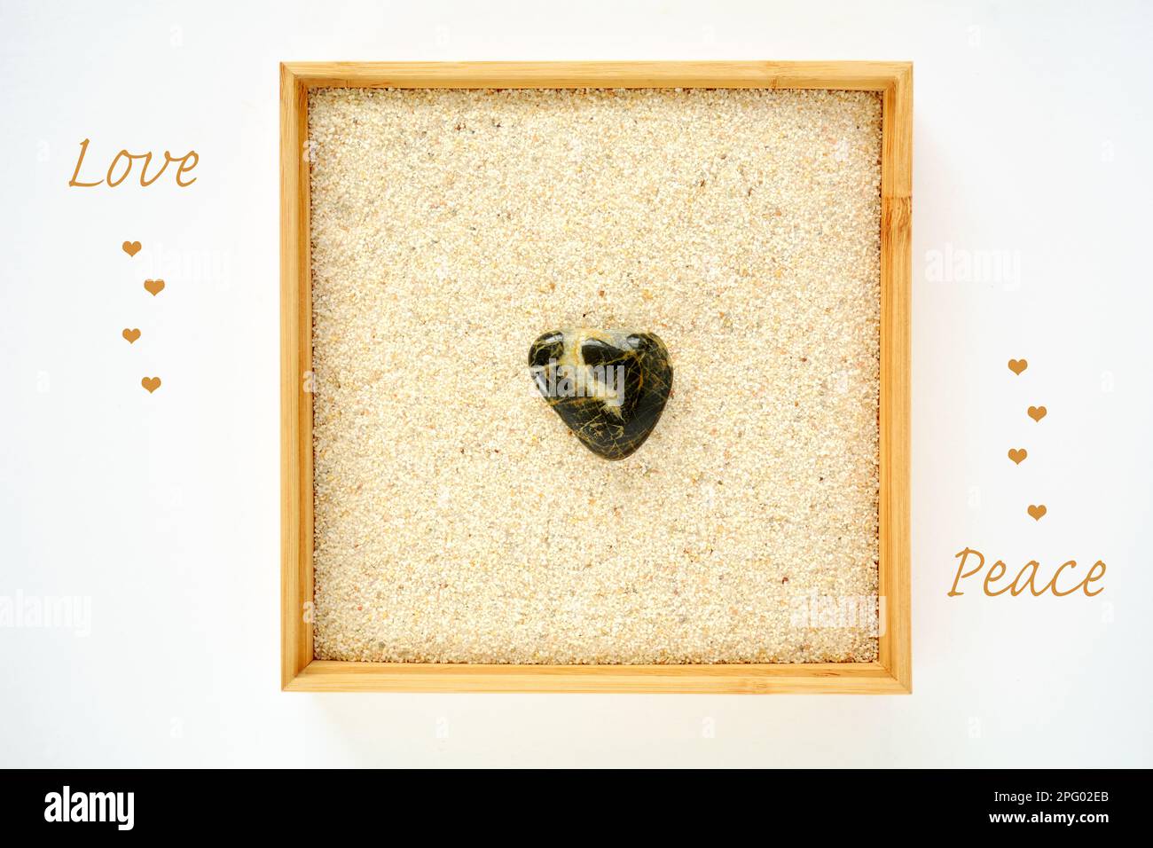 Heart shaped stone set in sand in bamboo tray represents a simple Zen ...