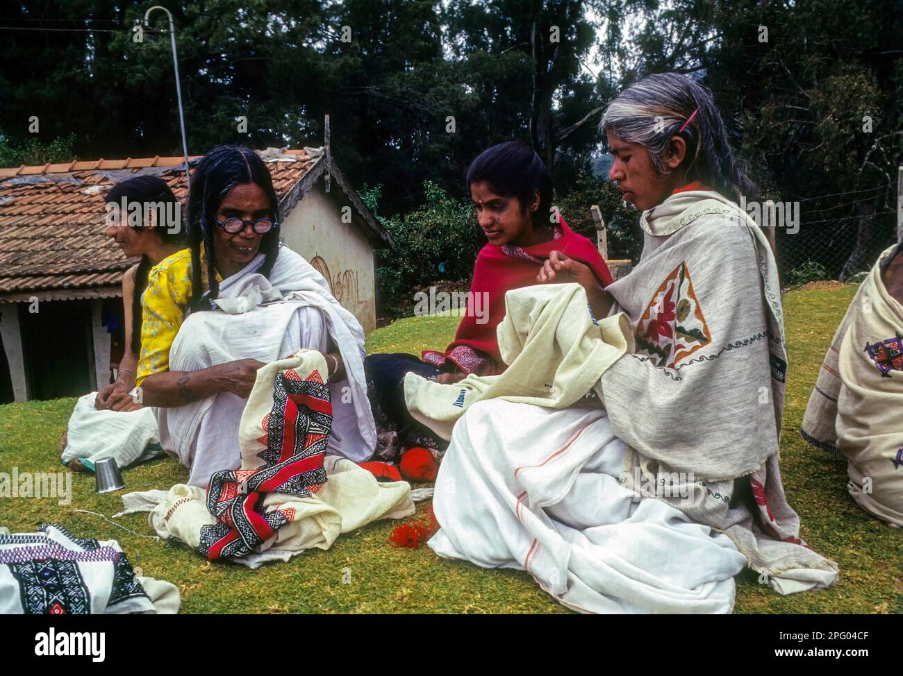 Toda ladies engage in embroidery work on their traditional costume the ...