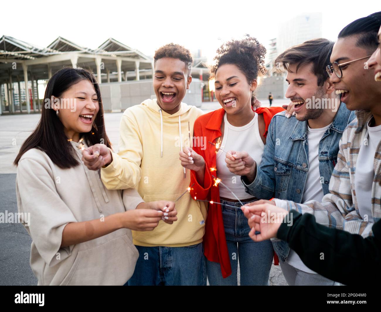 Group of diverse millennial youth celebrating with sparklers. Concept ...