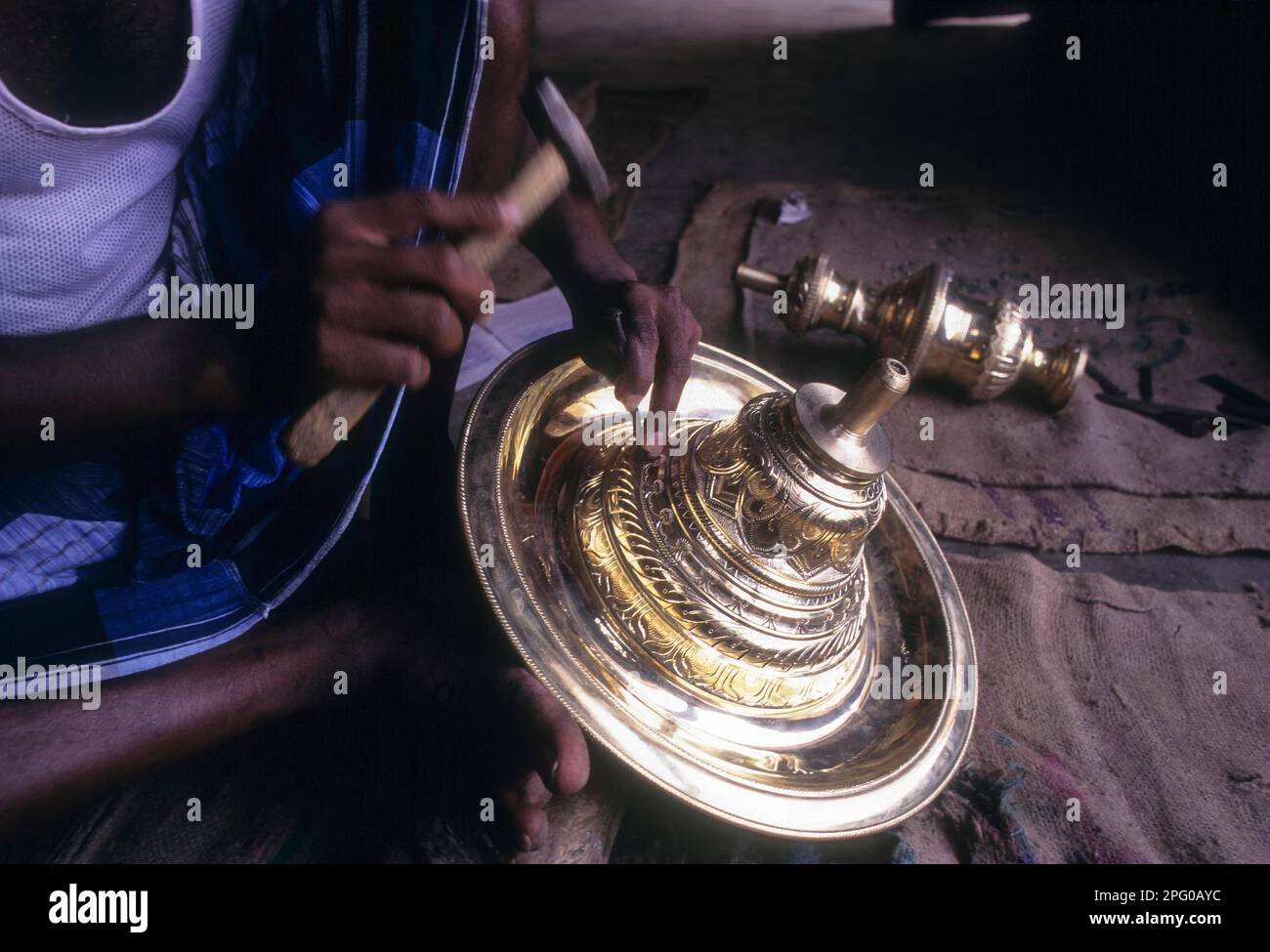 An artisan working on brass lamp at Nachiyar Koil near Thanjavur, Tamil ...