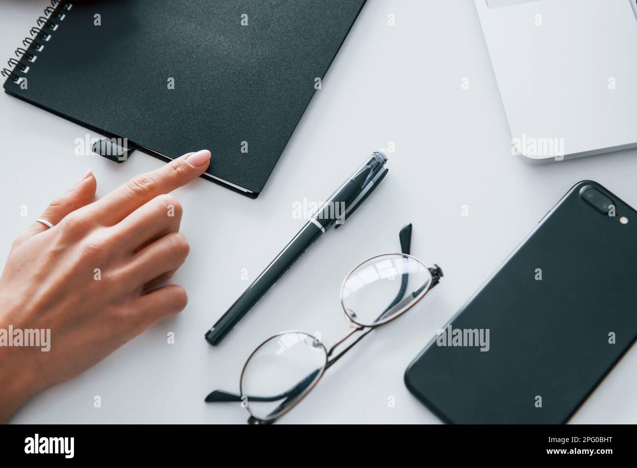Woman's hands holding black colored notepad that lying on the table ...
