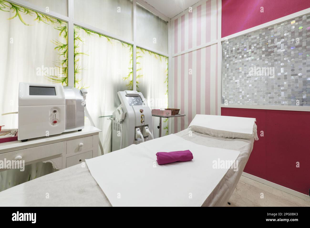 A massage cabin with a stretcher covered with paper and machines to ...