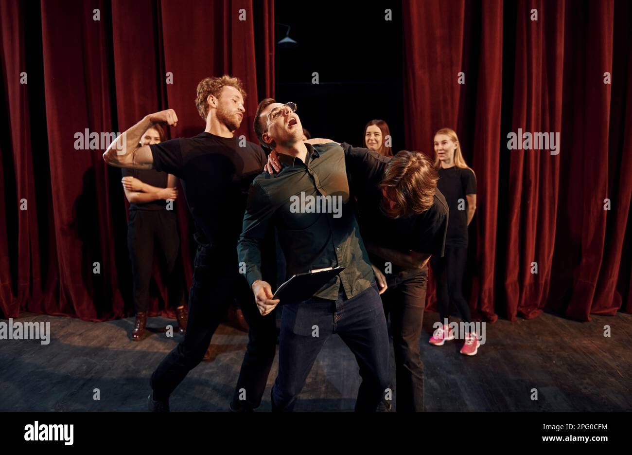 Fight scene. Group of actors in dark colored clothes on rehearsal in ...