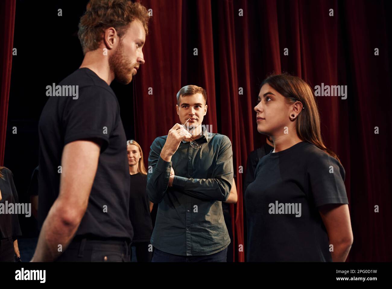 Two people talking. Group of actors in dark colored clothes on ...