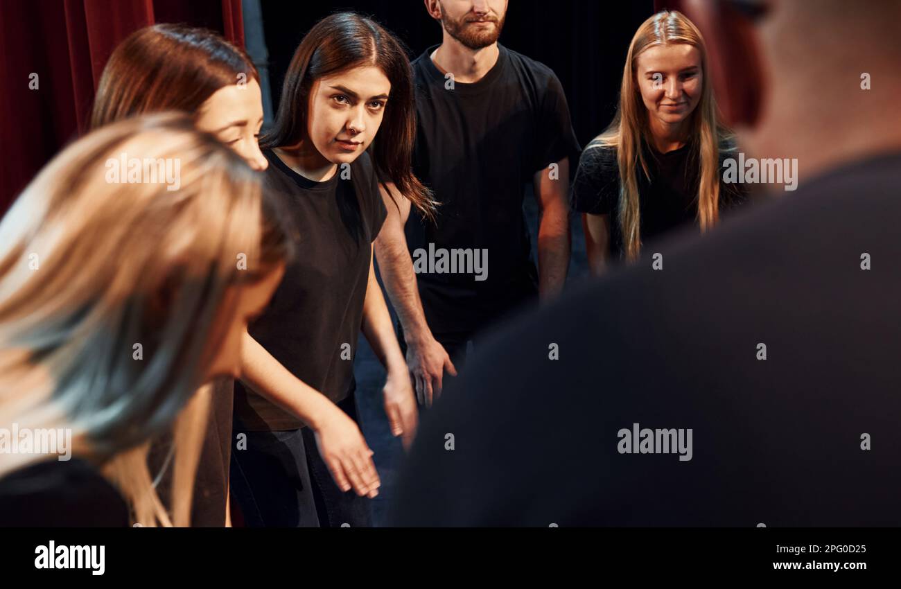 Group of actors in dark colored clothes on rehearsal in the theater ...