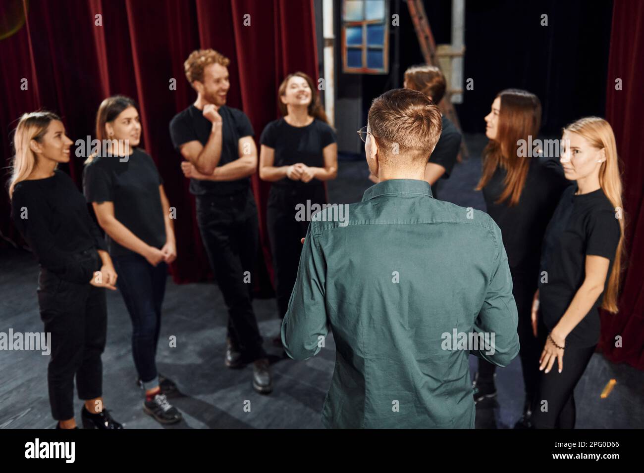 Working together. Group of actors in dark colored clothes on rehearsal ...