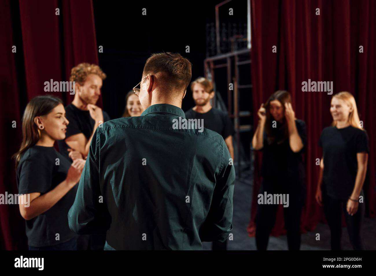 Working together. Group of actors in dark colored clothes on rehearsal ...