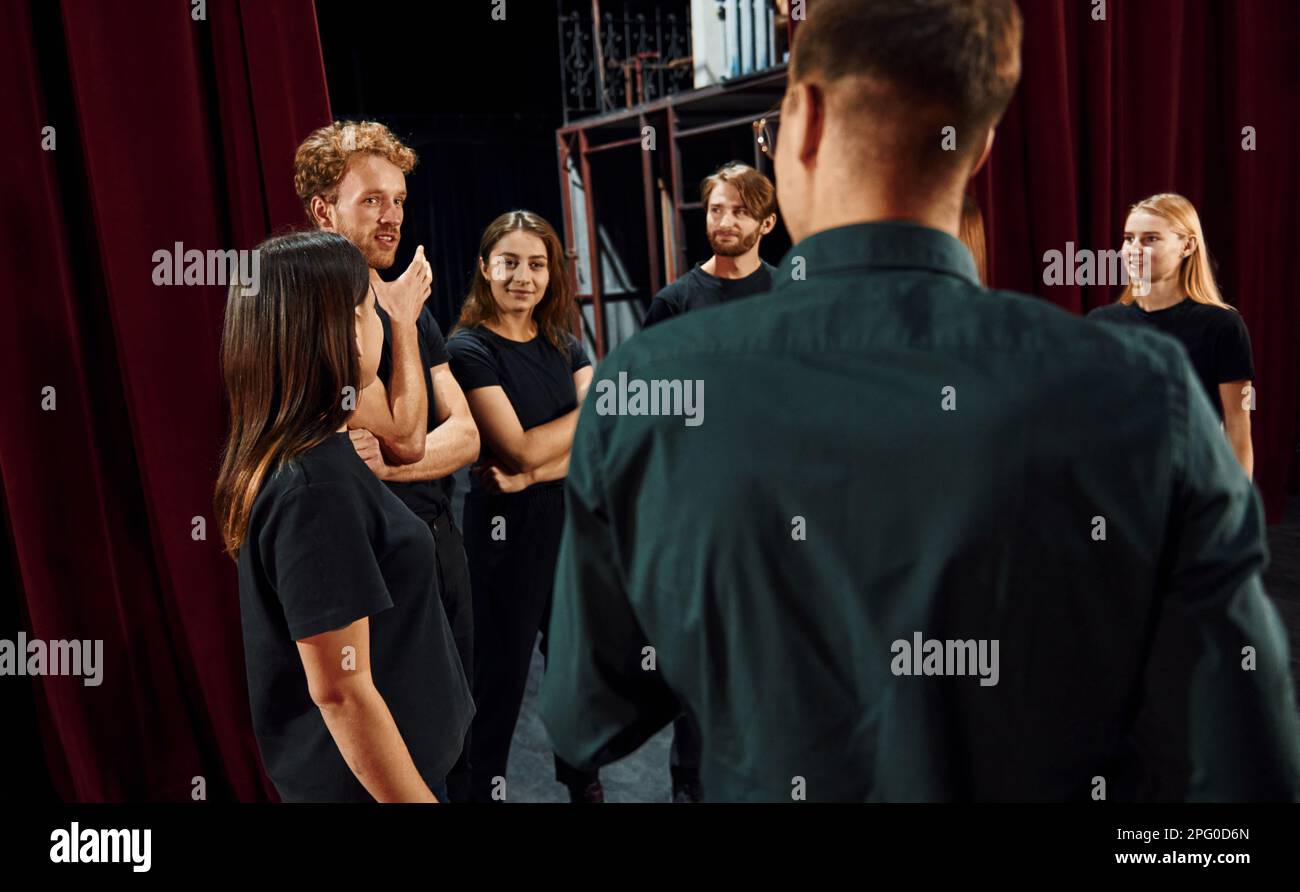 Working together. Group of actors in dark colored clothes on rehearsal ...