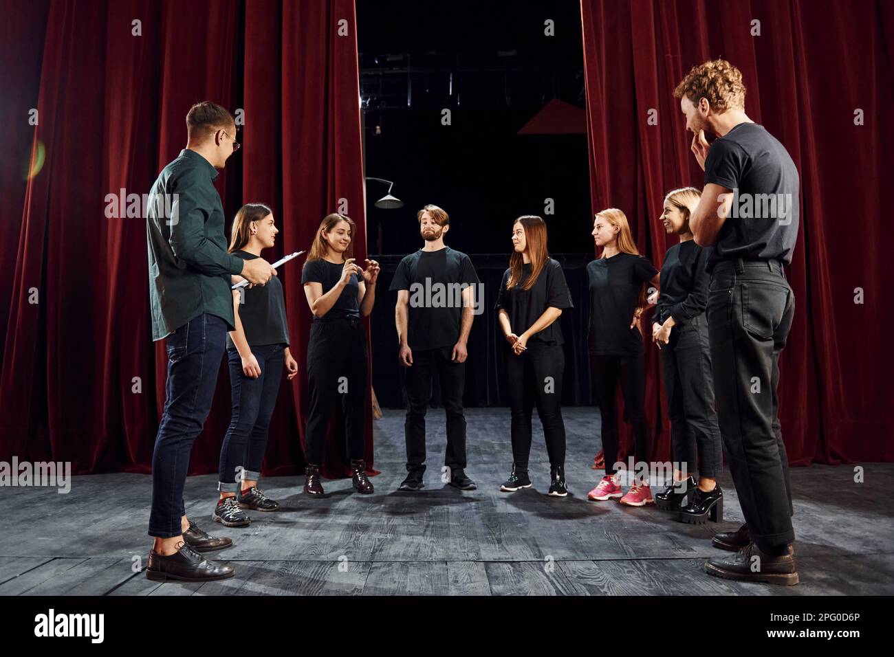 Working together. Group of actors in dark colored clothes on rehearsal ...