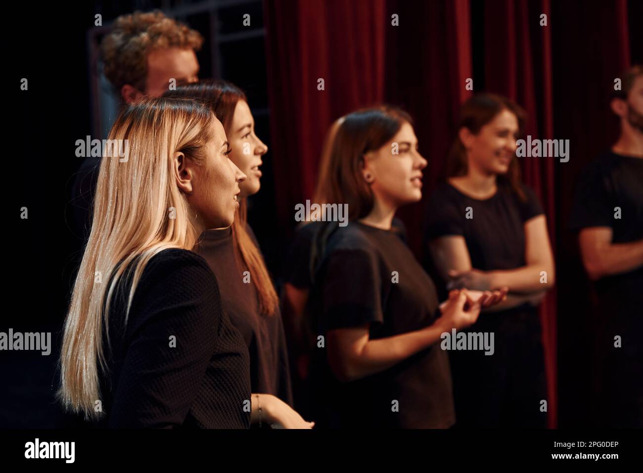 Side view. Group of actors in dark colored clothes on rehearsal in the ...