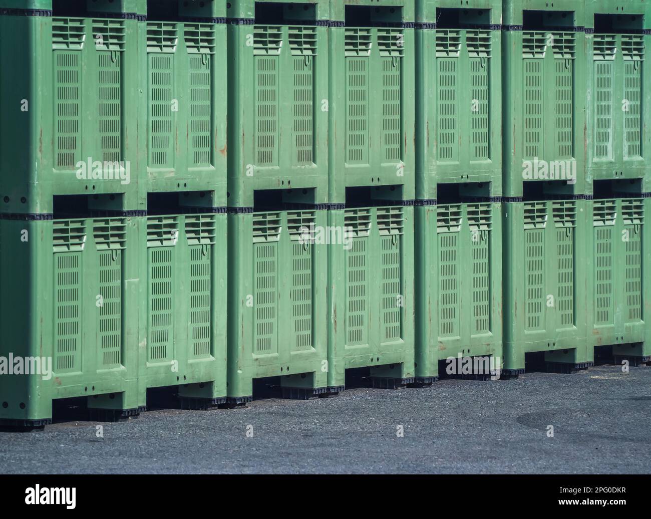 Big green plastic crates for fruits are stacked and waiting to be ...
