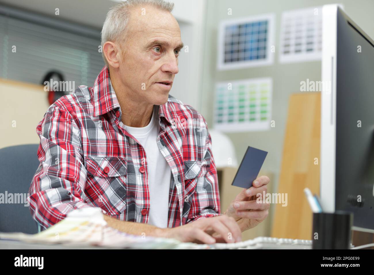 shop owner using a computer to look for reference Stock Photo - Alamy