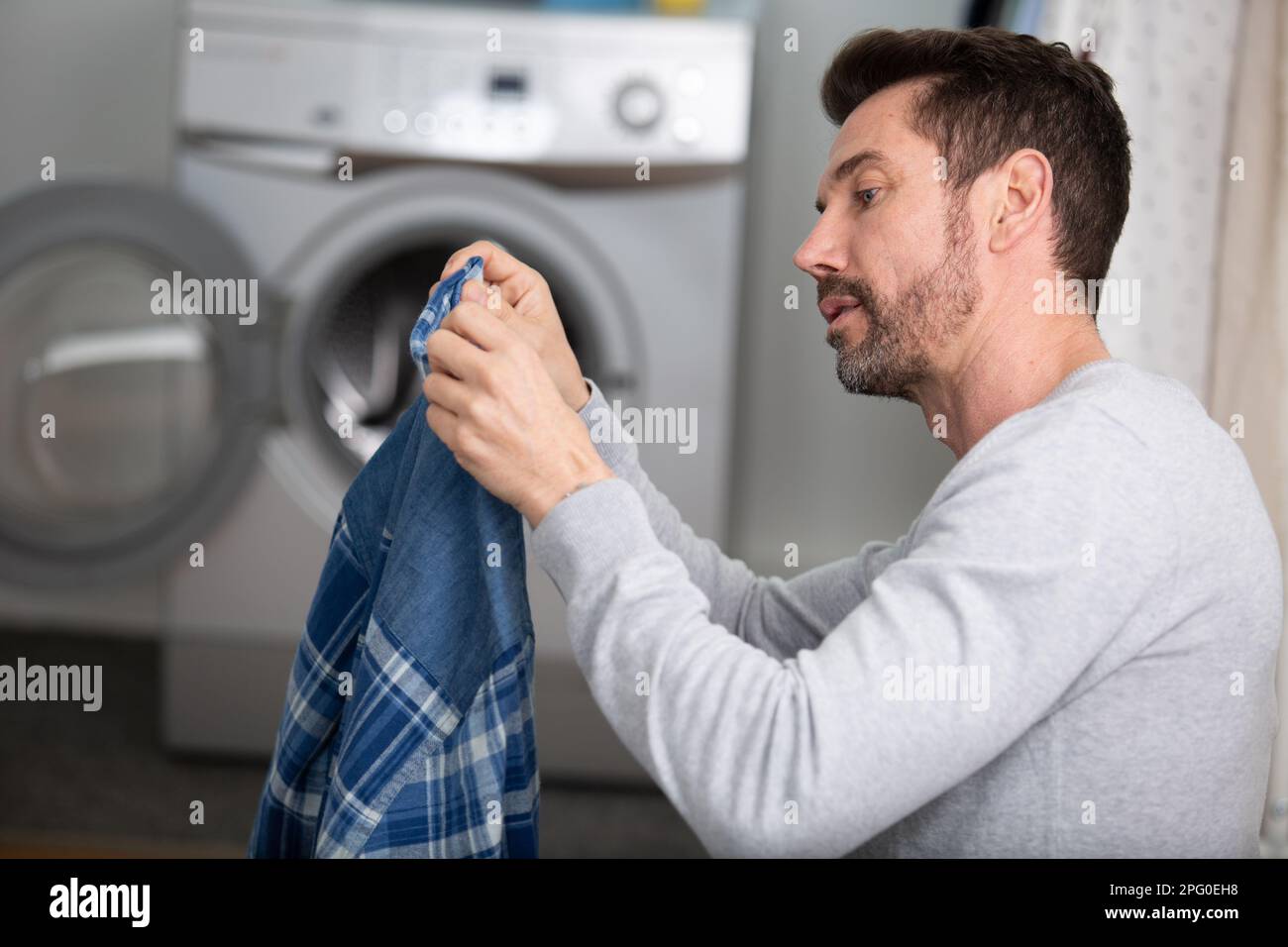 portrait of man doing his laundry Stock Photo - Alamy