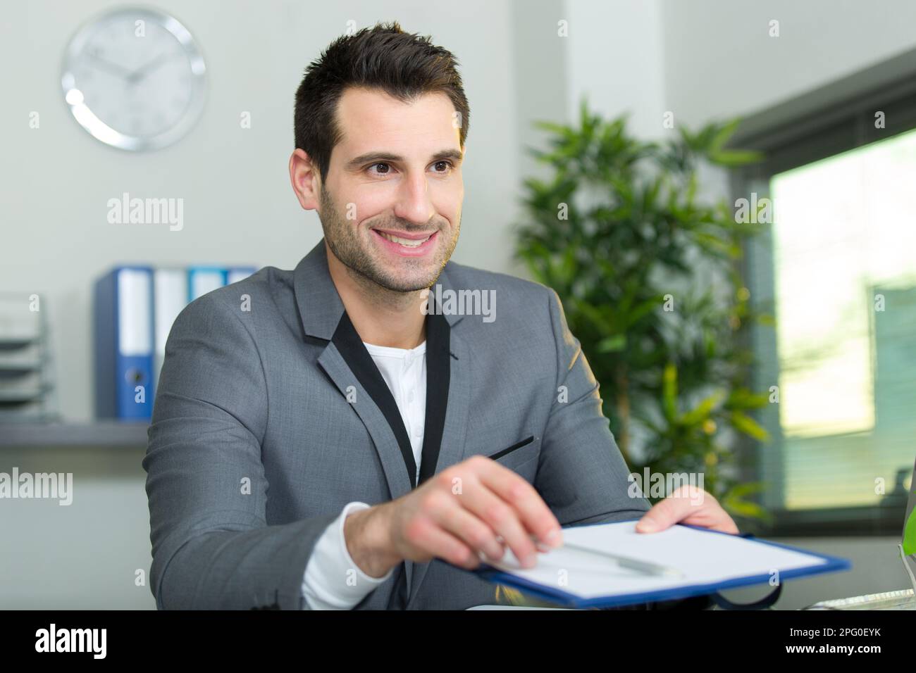 businessman passing clipboard to client for signature Stock Photo - Alamy