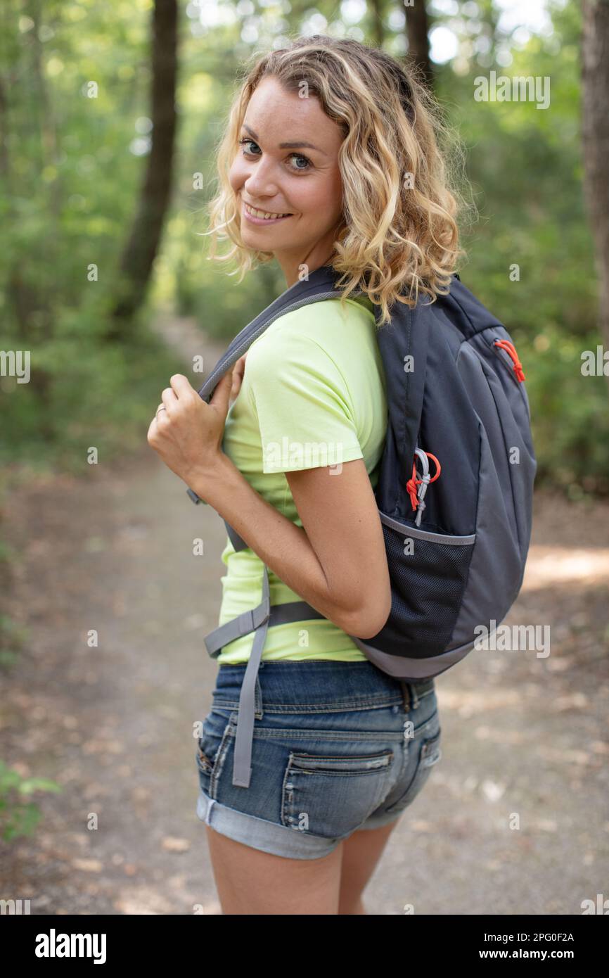 woman walking in the forest wearing a backpack Stock Photo - Alamy