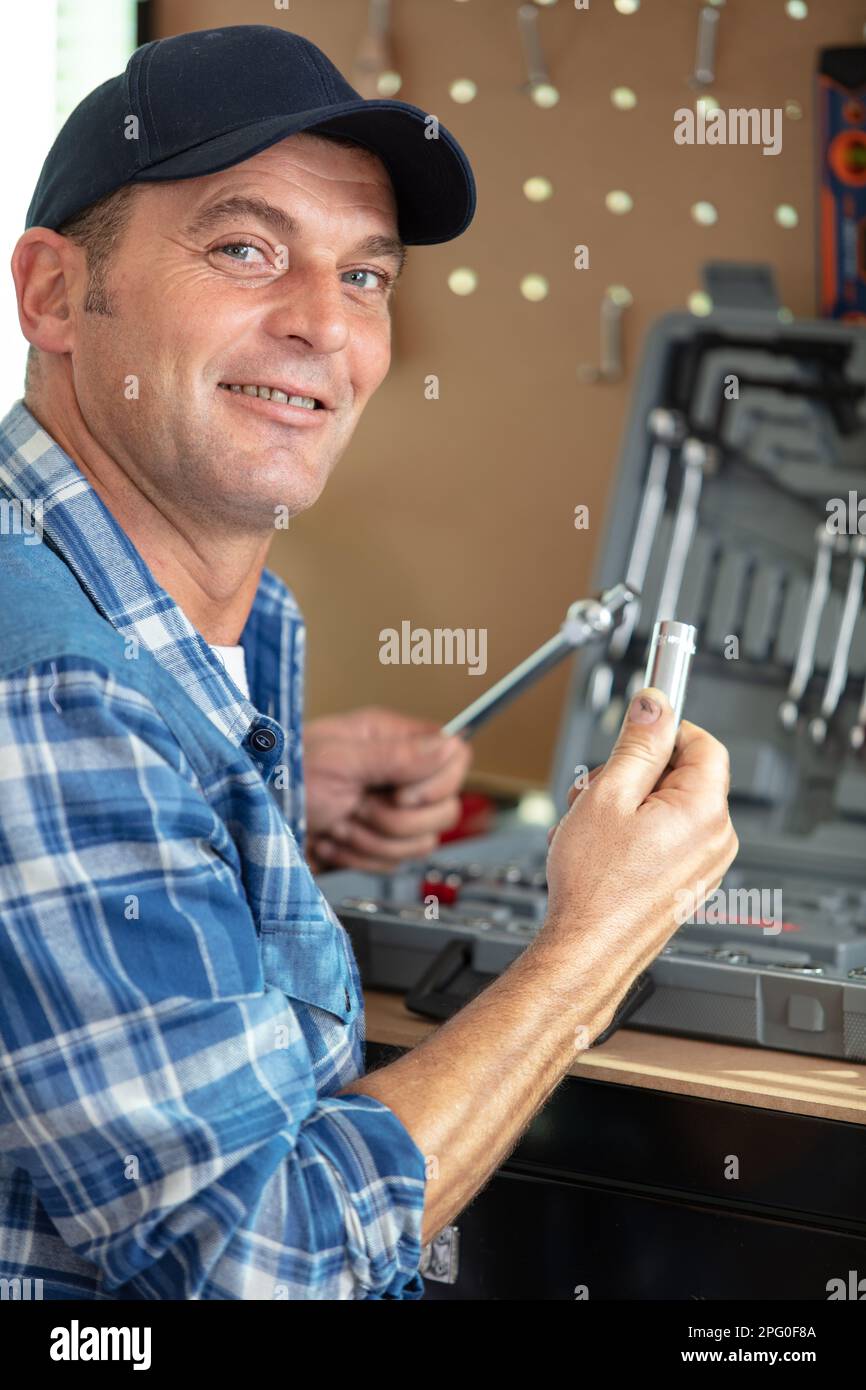 handyman sitting and holding toolbox Stock Photo - Alamy