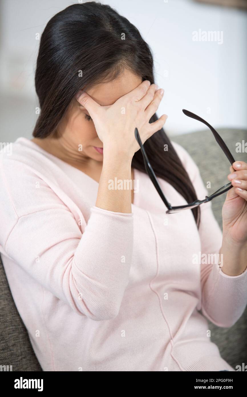 Tired woman taking off glasses hi-res stock photography and images - Alamy