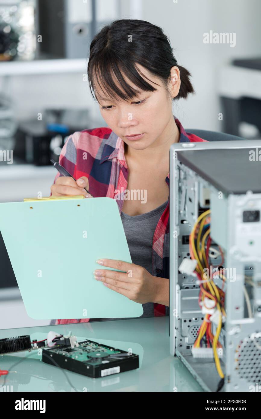 woman repairing computer taking notes Stock Photo - Alamy