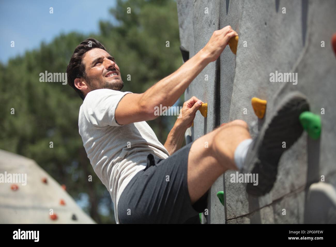 Man scaling climbing wall hi-res stock photography and images - Alamy