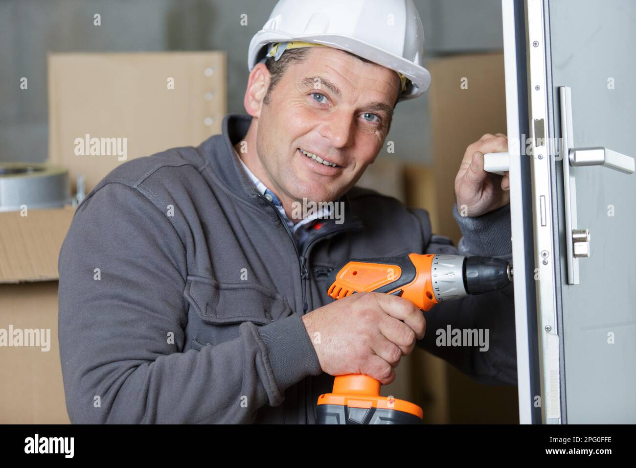 worker using cordless screwdriver on door lock Stock Photo - Alamy