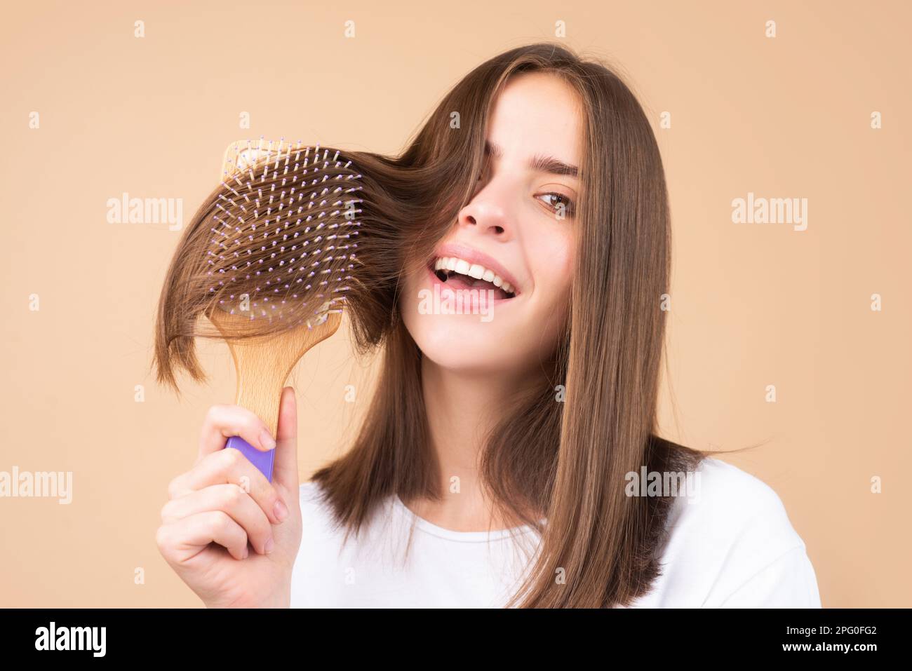 Young woman combing healthy and shiny hair, isolated on studio Stock ...
