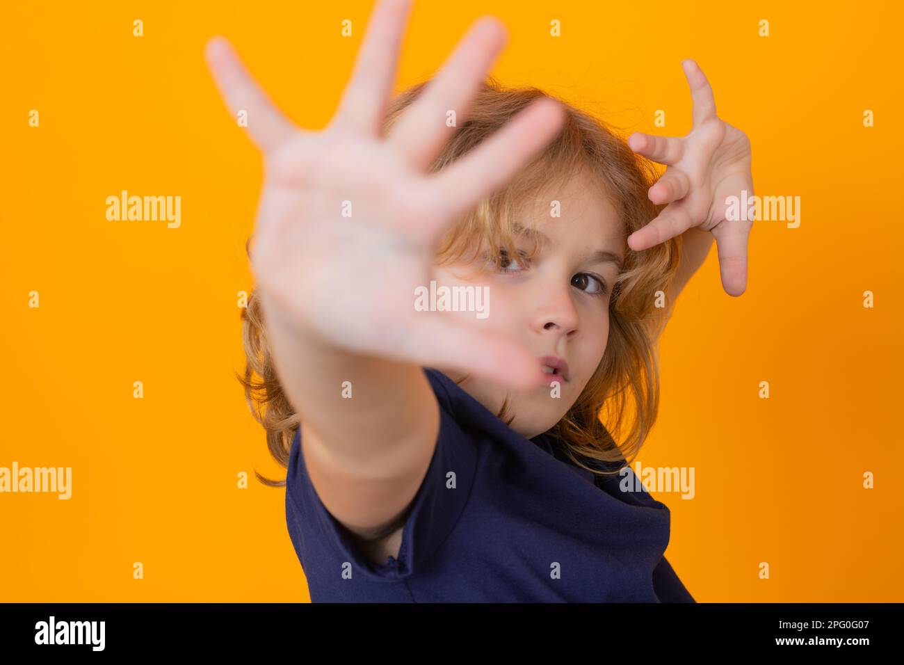 Child making stop gesture on yellow isolated studio background. Kid ...