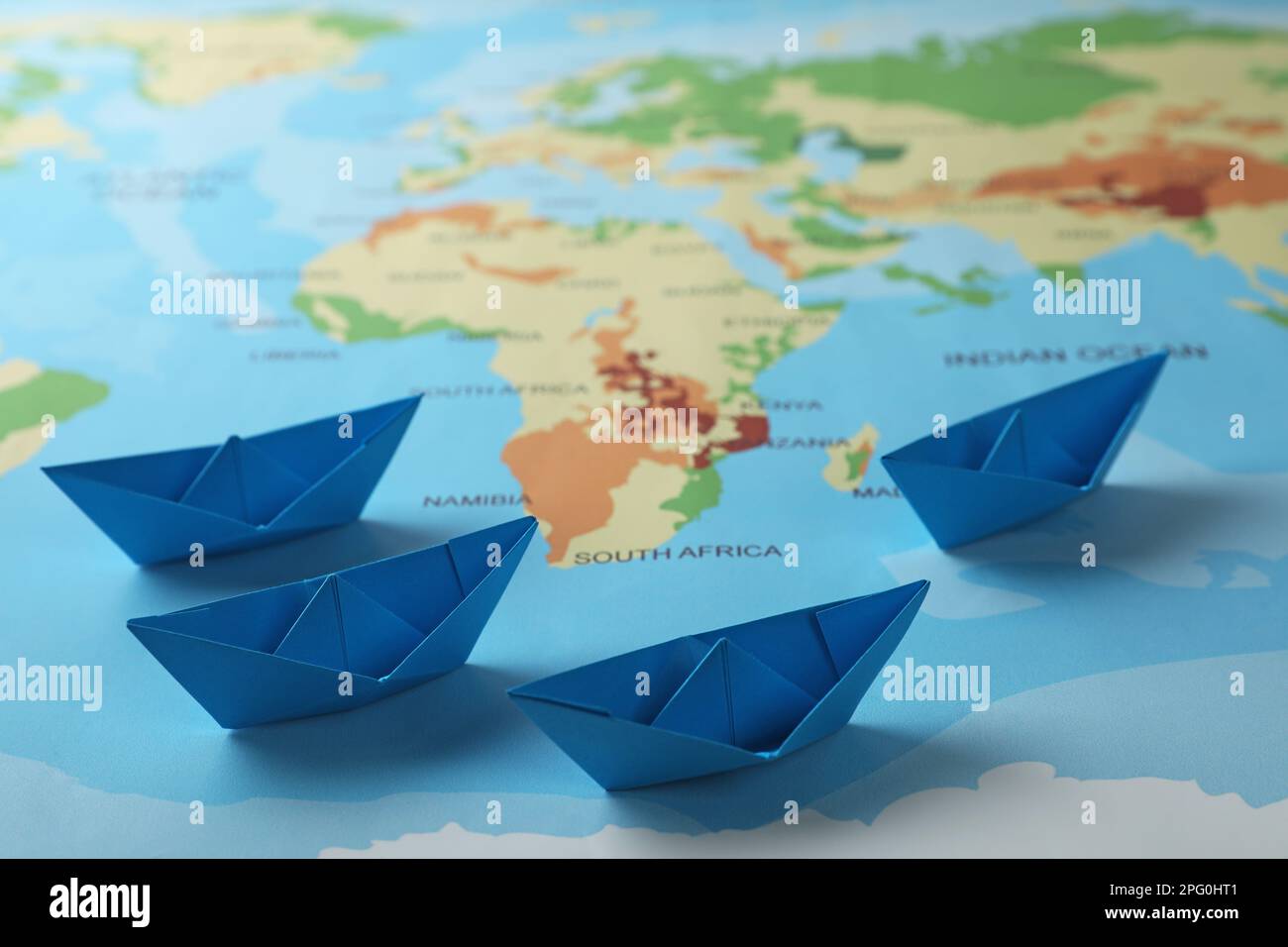 Light blue paper boats on world map Stock Photo - Alamy