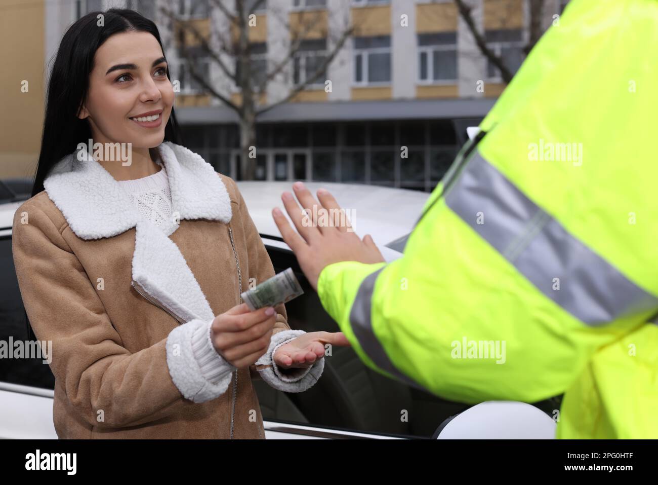 Police officer rejecting bribe near car outdoors Stock Photo - Alamy