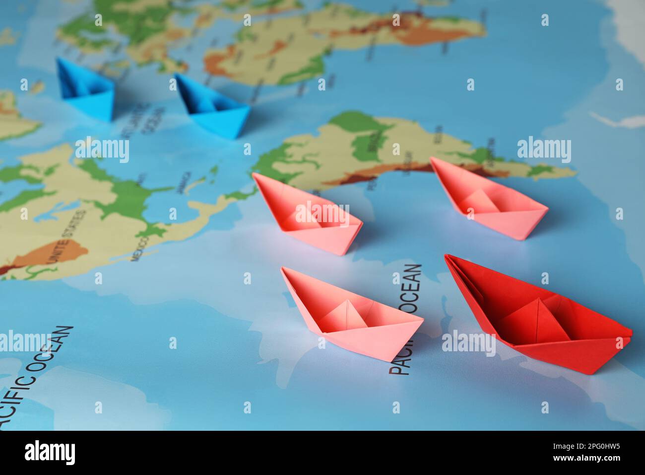 Group of colorful paper boats on world map Stock Photo - Alamy