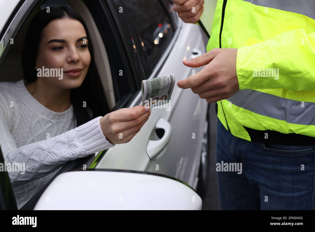 Woman giving bribe to police officer out of car window Stock Photo - Alamy