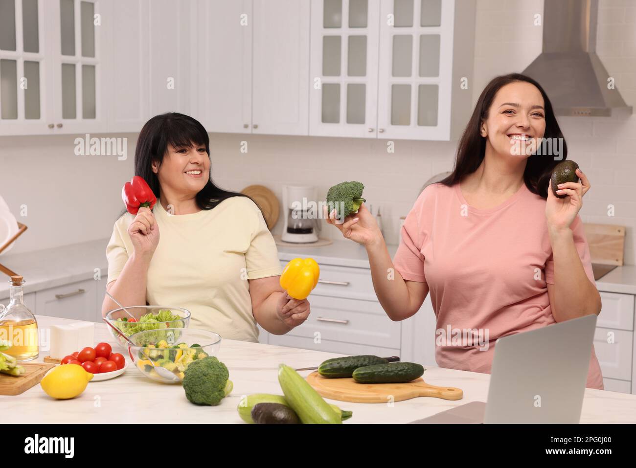 Happy overweight women having fun while cooking together in kitchen ...