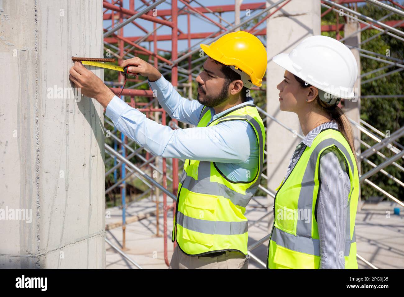 Engineer young man and woman using tape measure for check and examining ...