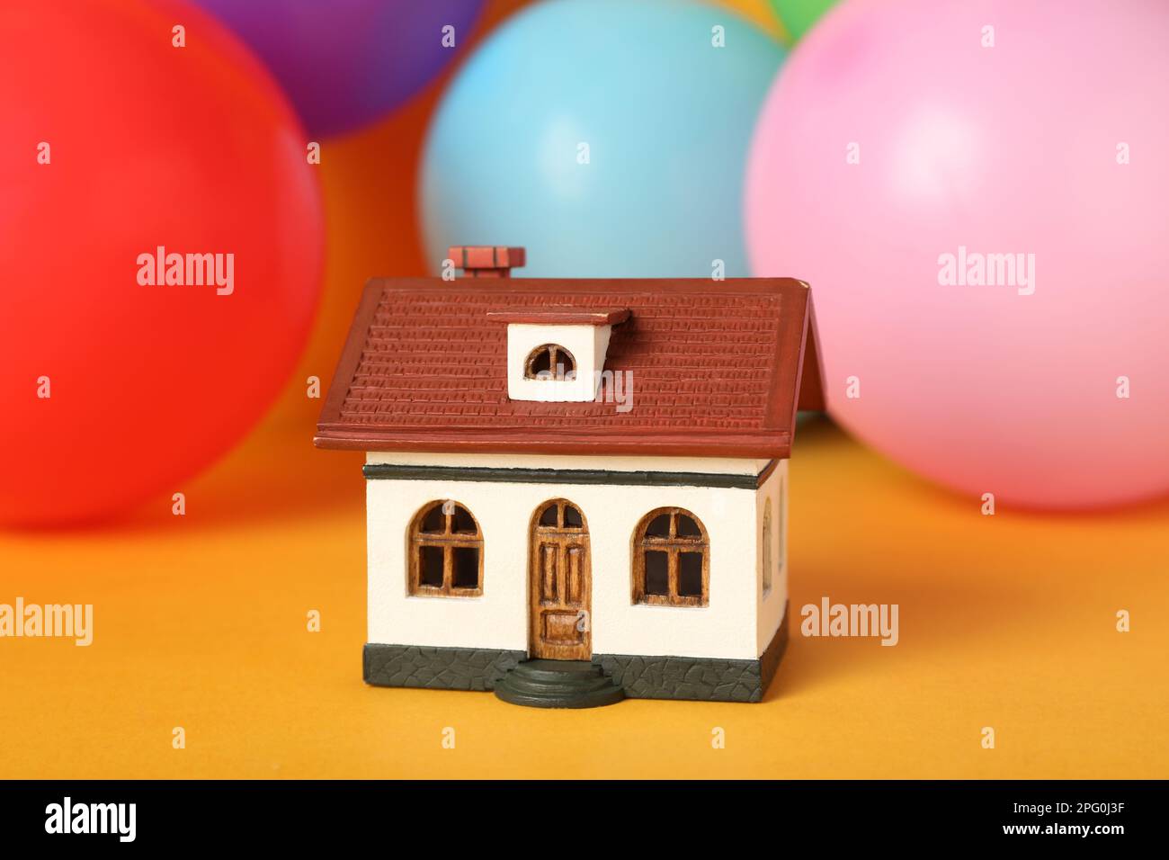 House model and balloons on yellow background. Housewarming party Stock ...