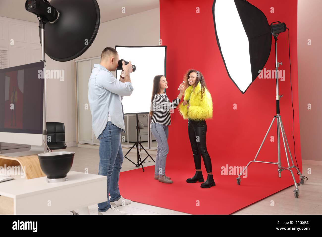 Professional photographer and makeup artist with model in studio Stock ...