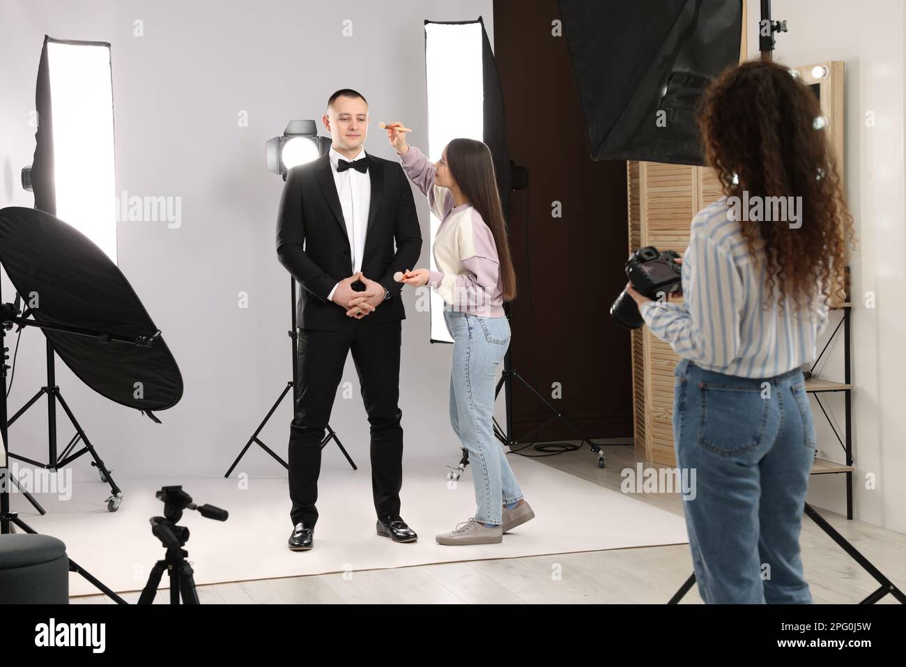 Professional photographer and makeup artist with model in studio Stock ...