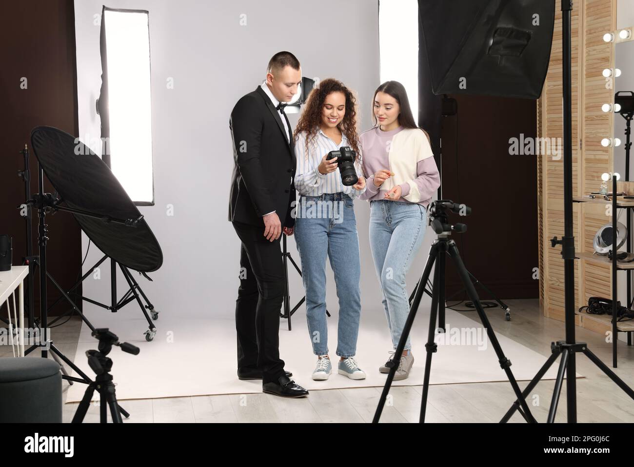 Professional photographer and makeup artist with model in studio Stock ...