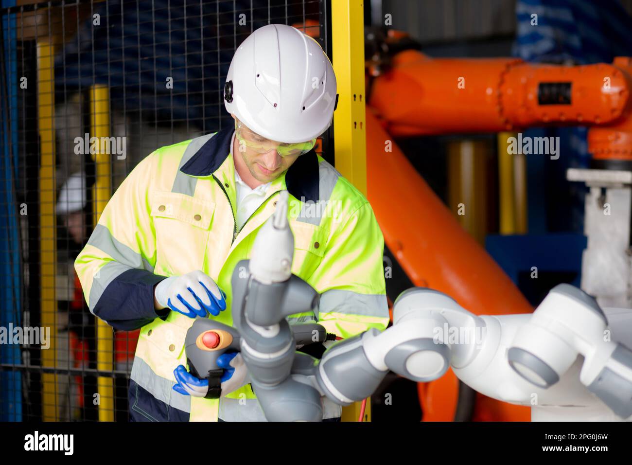 Young engineer man checking and maintenance machine robot arms ...