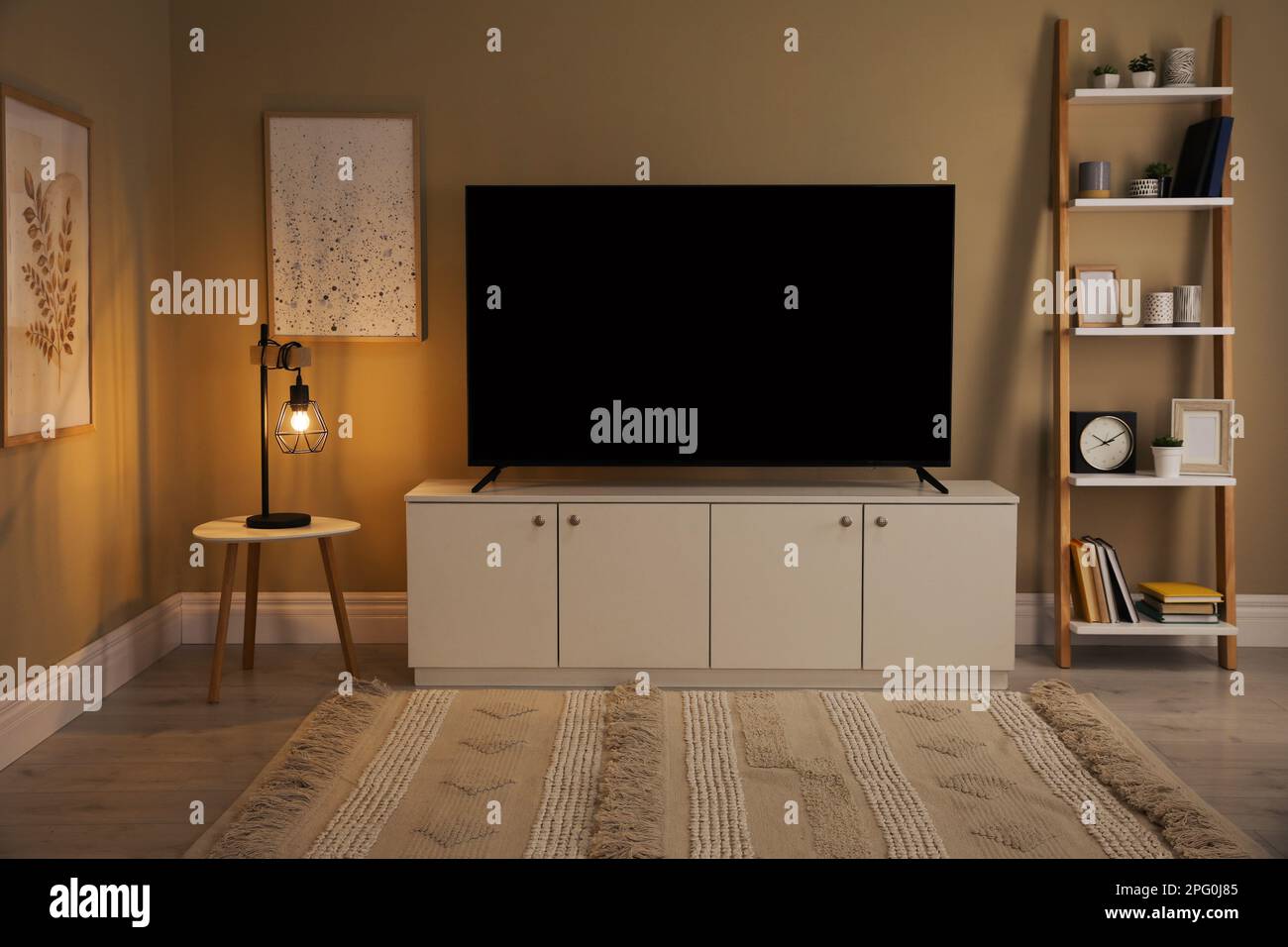 Modern TV on cabinet, white table and shelving unit near beige wall in ...