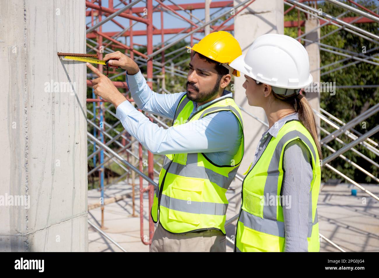 Engineer young man and woman using tape measure for check and examining ...