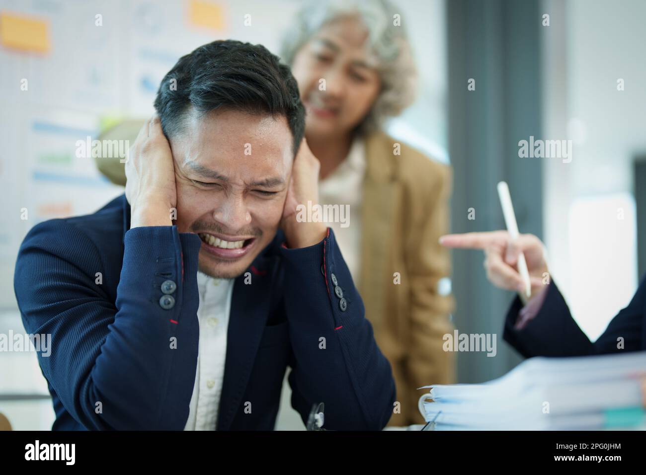 An image of an Asian male employee looking worried and sad about being ...