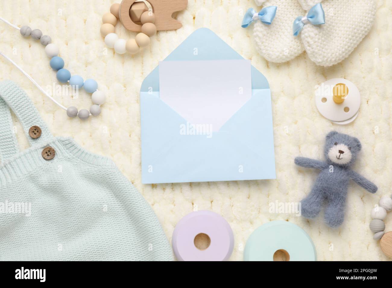 Baby shower party. Envelope surrounded by stuff for child on light ...