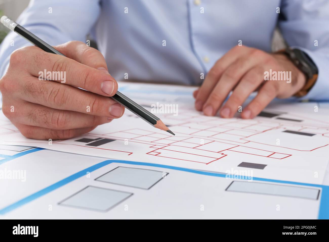Professional cartographer working with cadastral map at table, closeup ...
