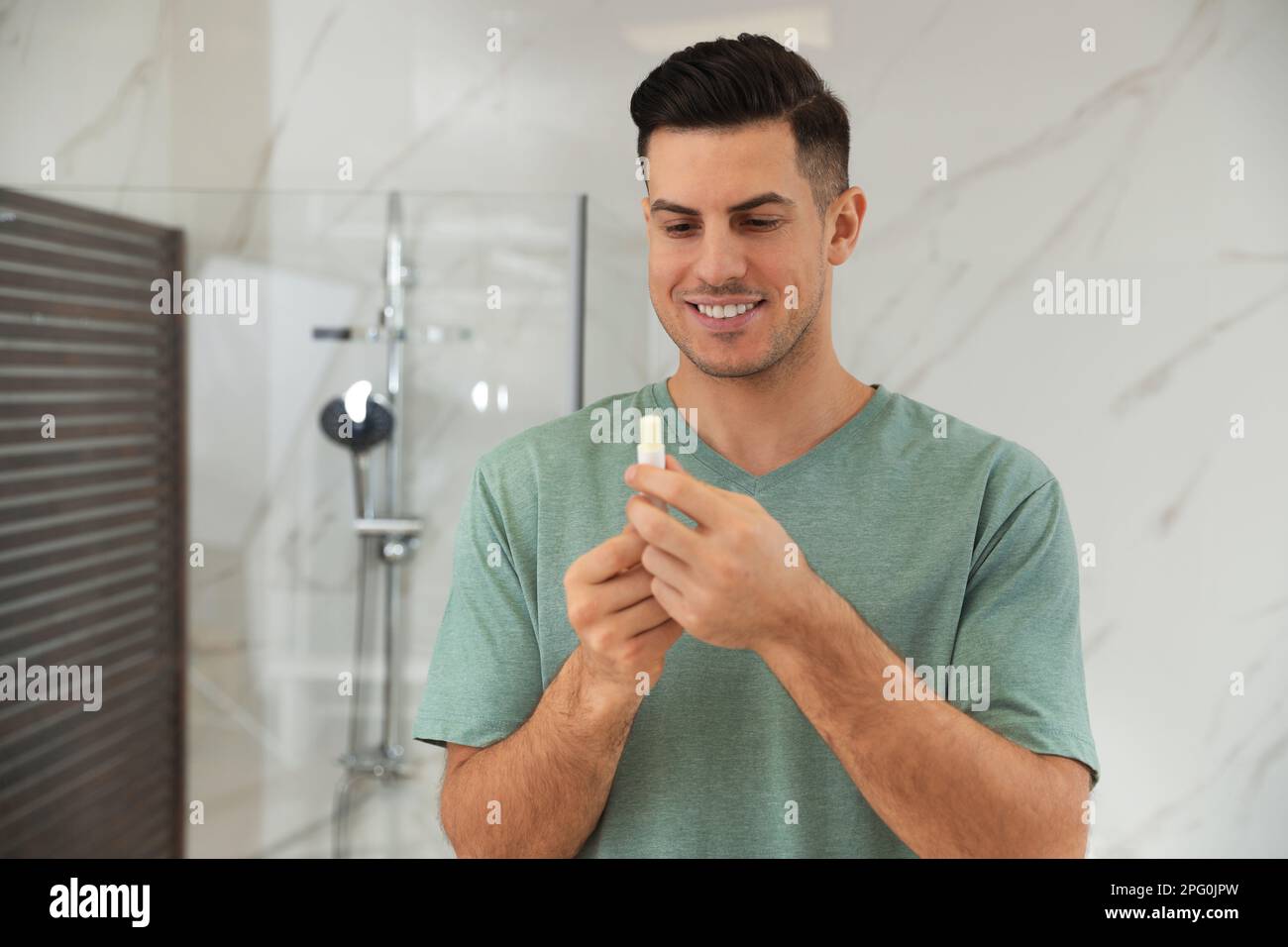Man applying hygienic lip balm in bathroom Stock Photo - Alamy