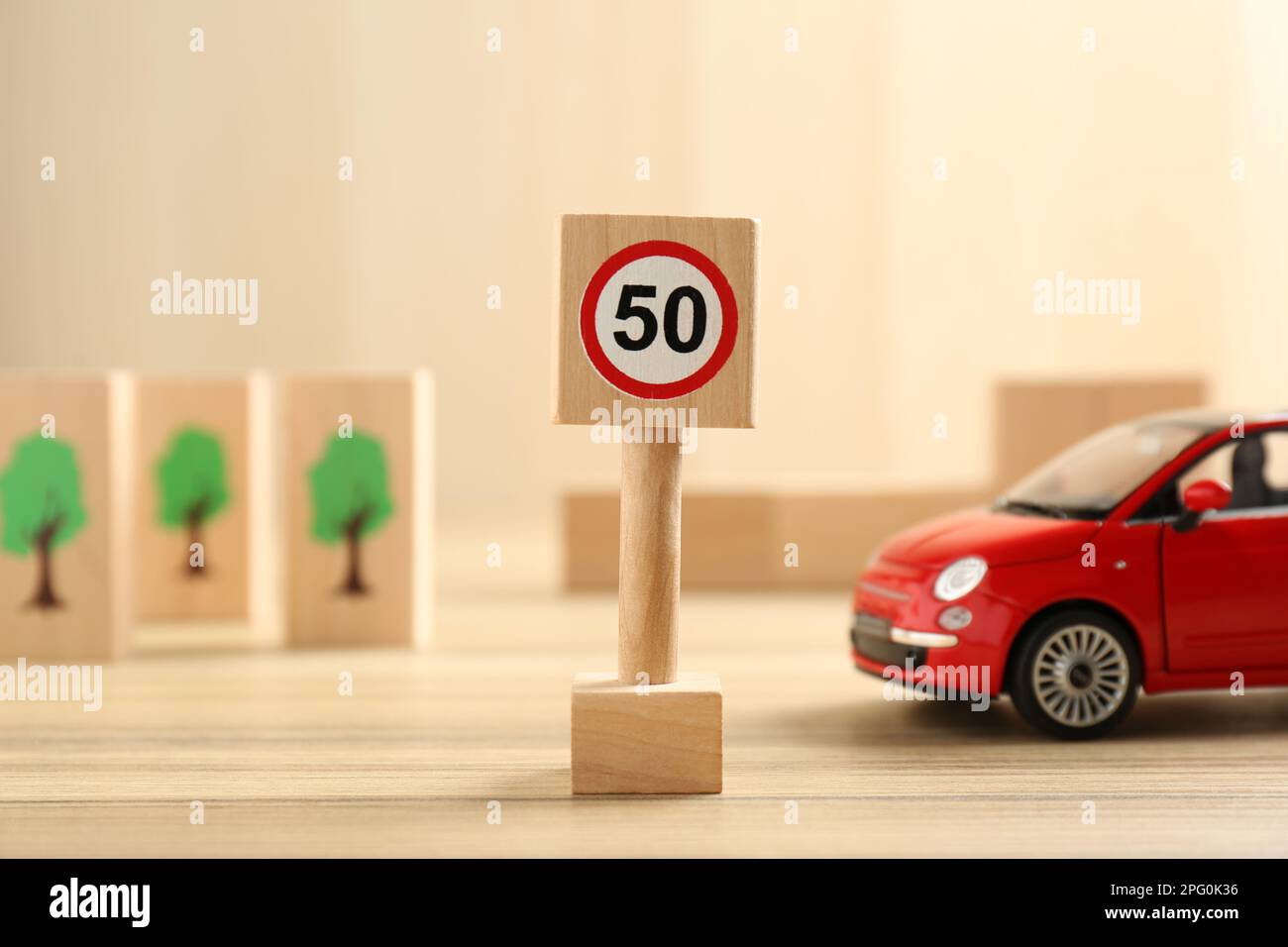 Traffic sign Maximum speed and toy car on wooden table. Passing driving ...