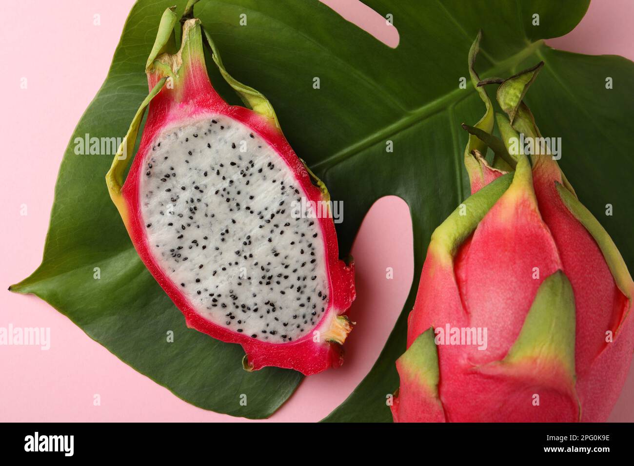 Delicious cut and whole white pitahaya fruits with green leaf on light ...