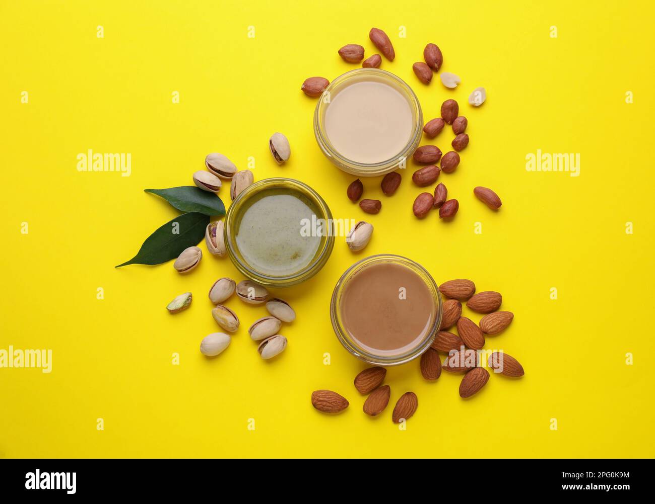 Different types of nut butter and ingredients on yellow background ...