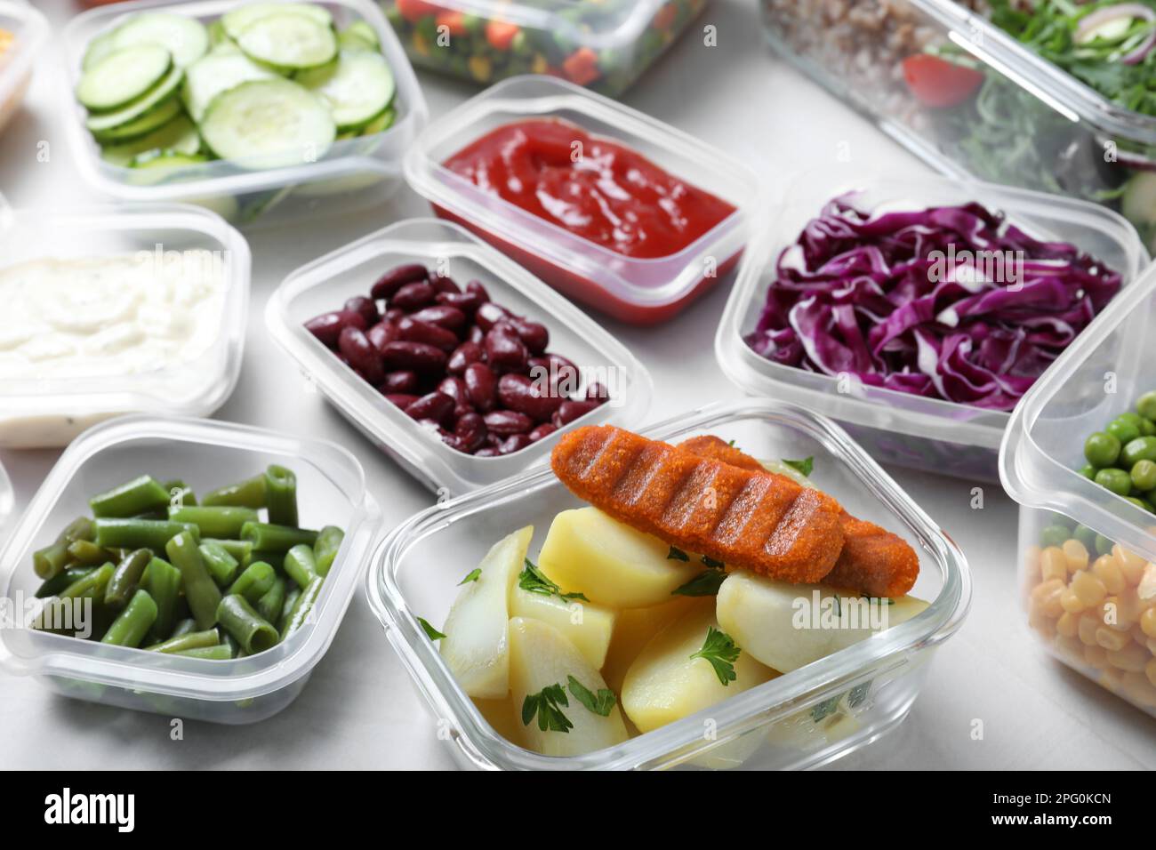 Set of containers with fresh food on white table Stock Photo - Alamy