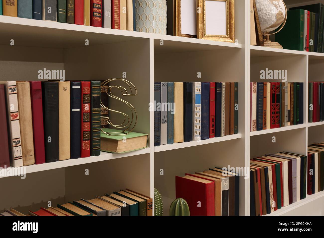 Collection of different books and decorative elements on shelves in ...